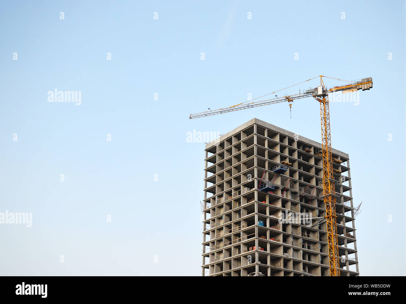 Jib construction tower crane at a construction site on the blue sky ...