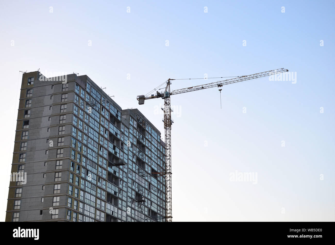 Jib construction tower crane at a construction site on the blue sky ...