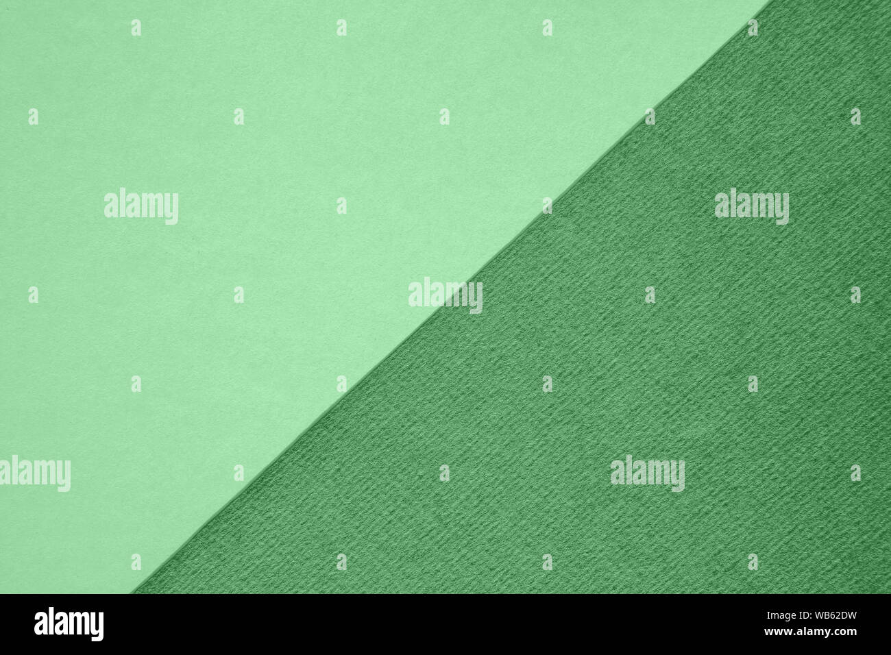 Textured and plain paper sheets divided diagonaliy creating line ...