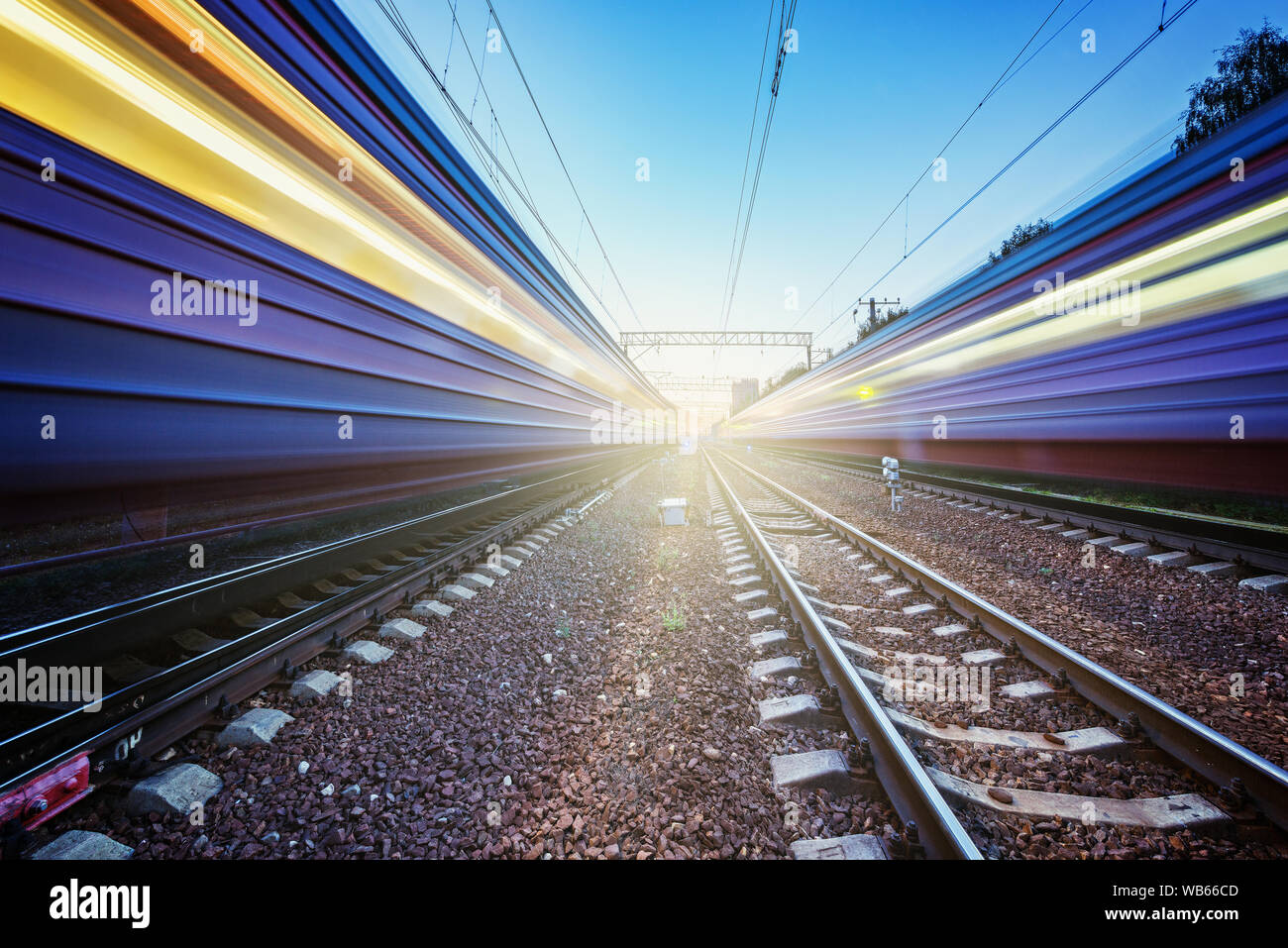 Two trains move fast to the different directions at sunset time Stock ...
