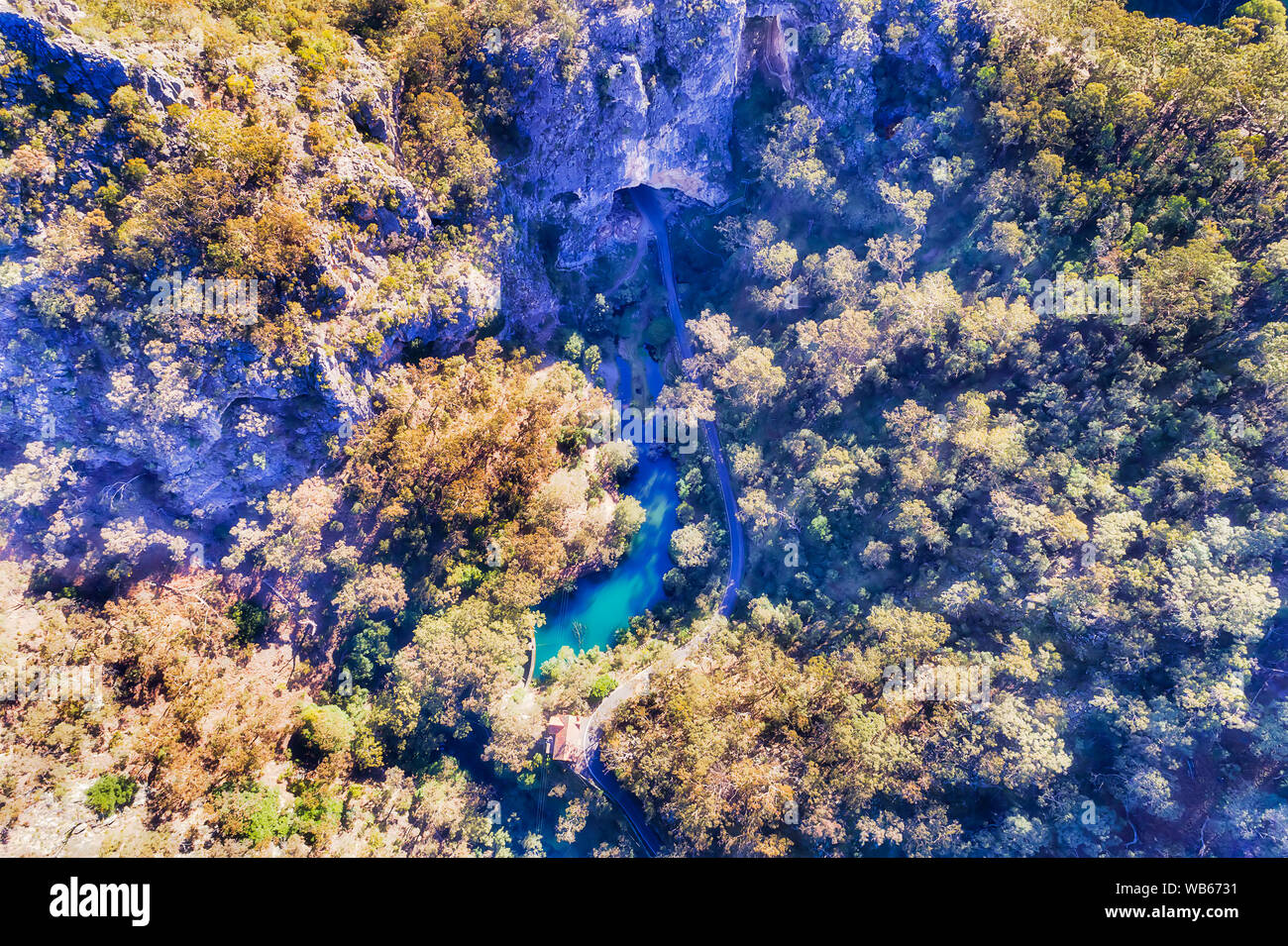 Tiny Blue Lake on Jenolan river between tall steep mountains in BLue ...