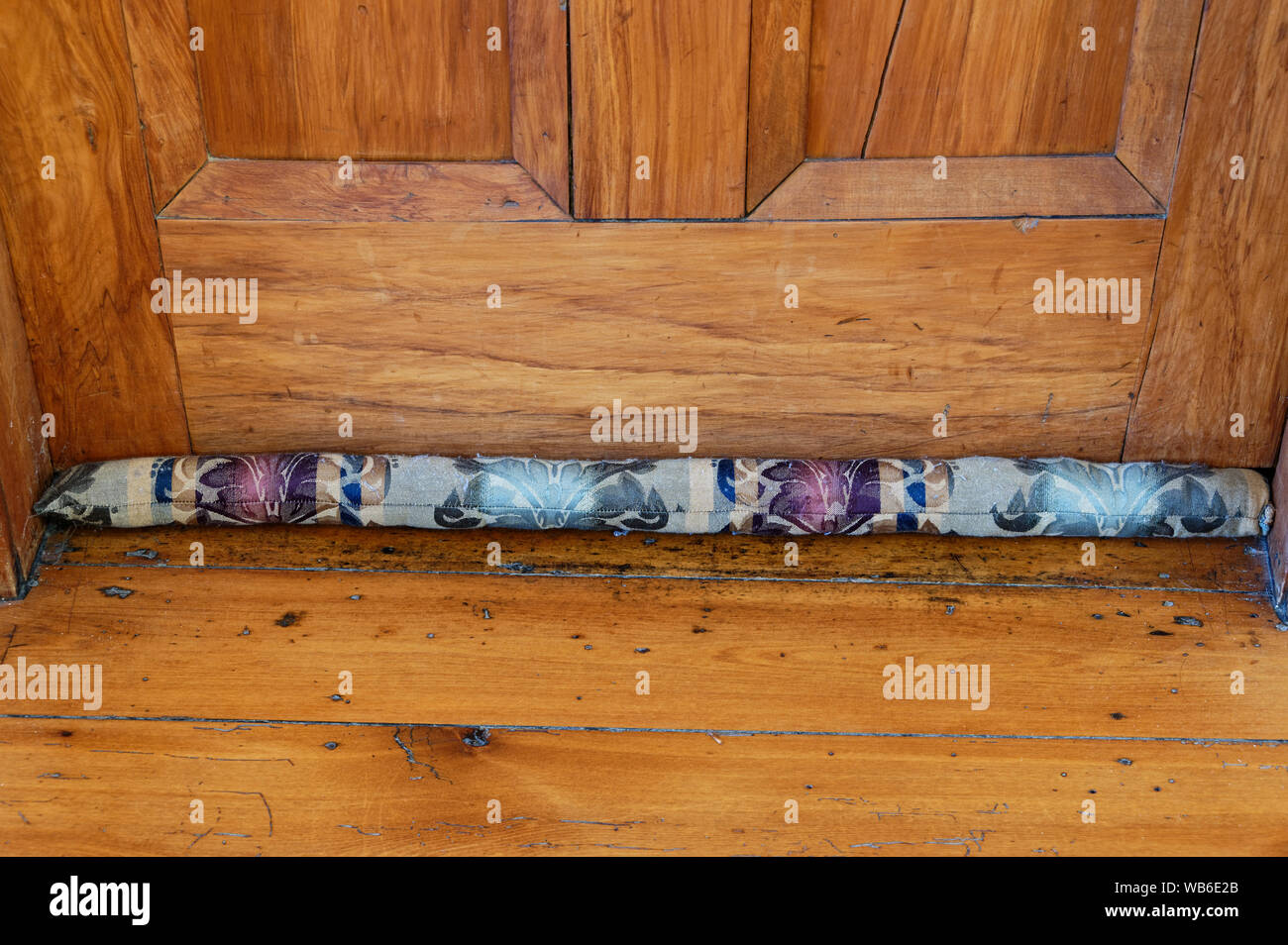 A material draft stopper stopping draughts from cooling a room Stock ...
