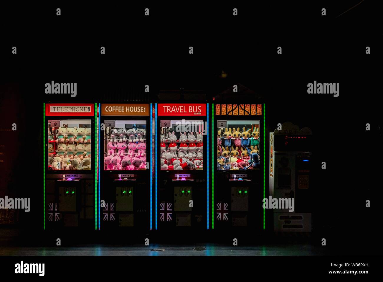 Dark shot of claw machines at an amusement park at night with no people ...