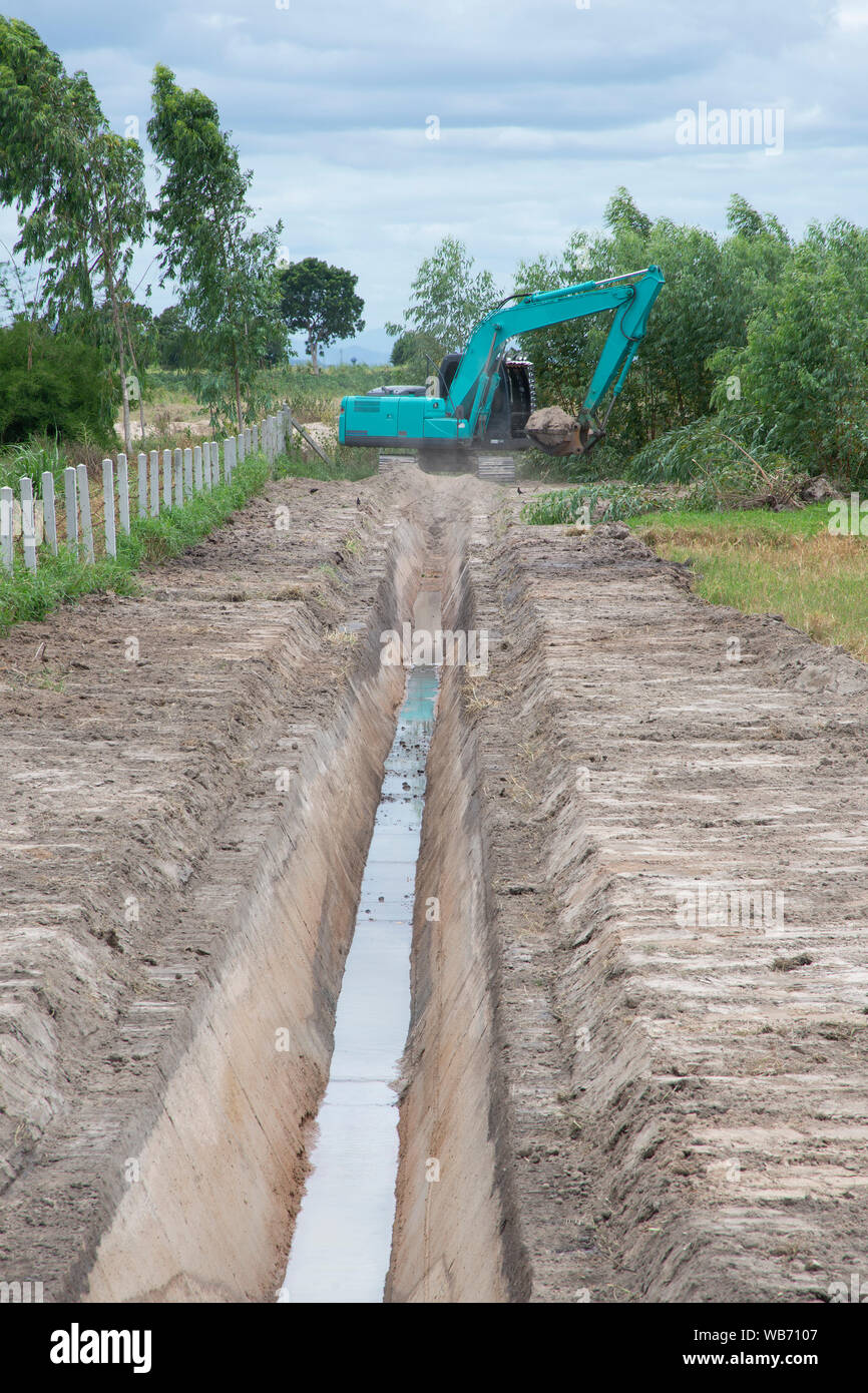 Backhoe digging waterway at agriculture area Stock Photo - Alamy