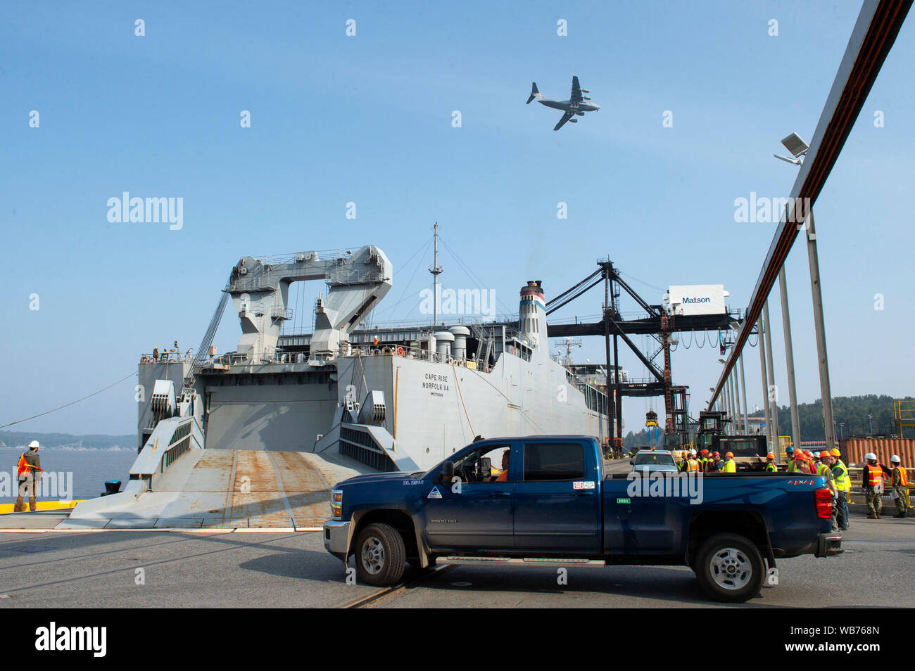 Longshoremen load military vehicles and equipment containers belonging ...