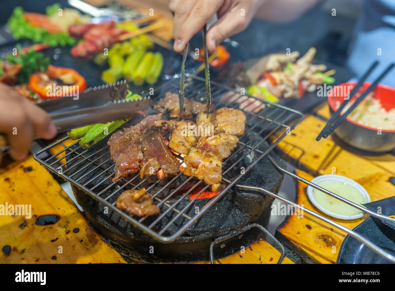 Human hands using tongs and grilling meat in barbecue party Stock Photo ...