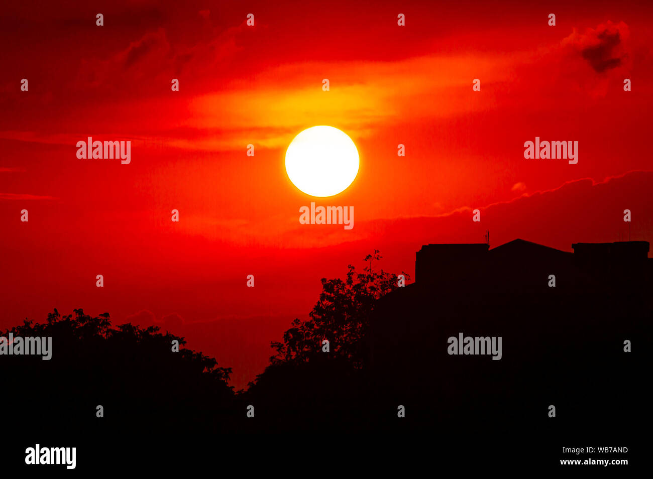 Red sunny sunset on a background of houses. Horizon Stock Photo - Alamy