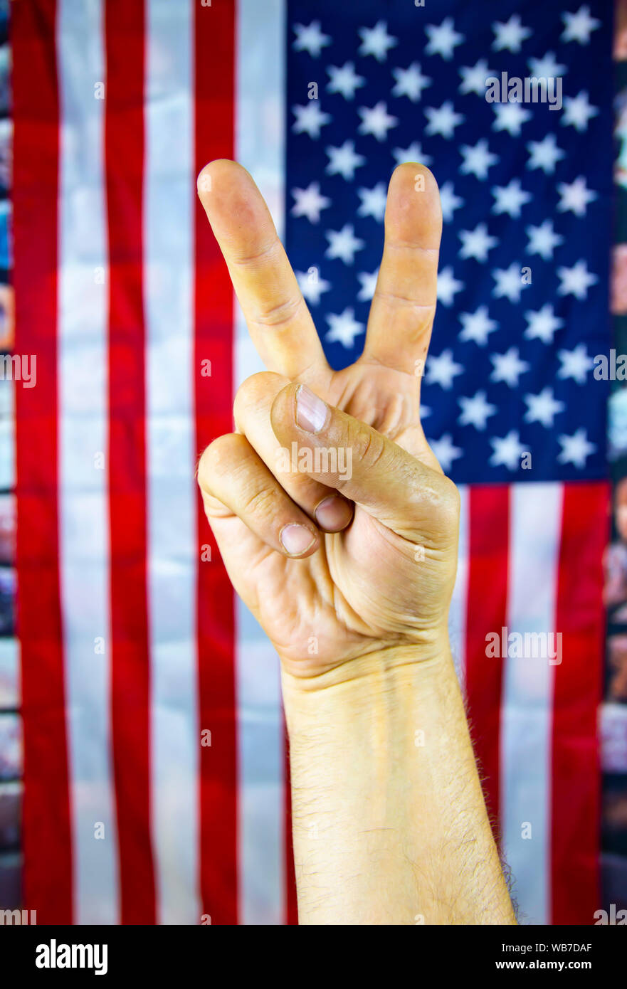 Hand gesture against the background of the flag of the United States of ...