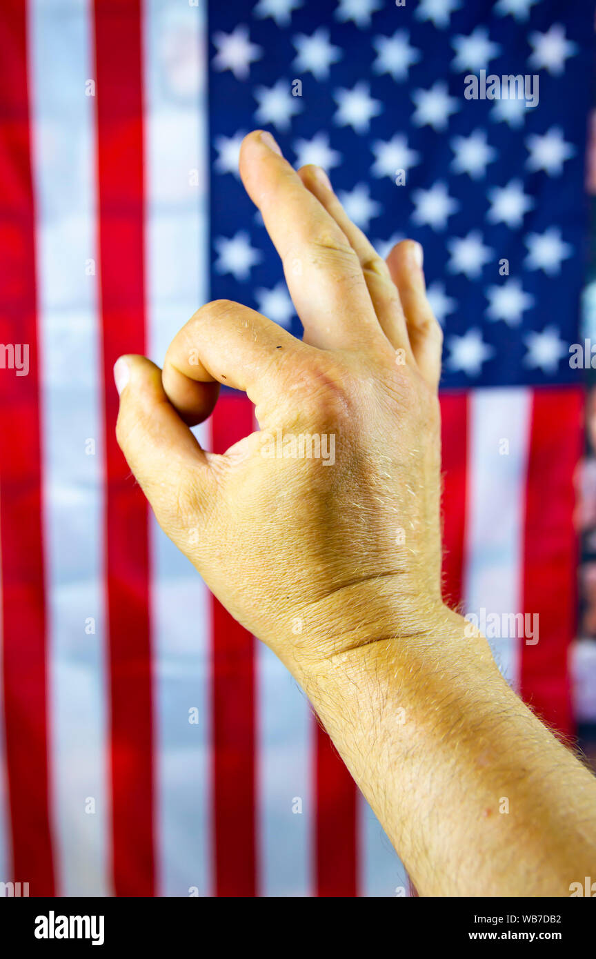 Hand gesture against the background of the flag of the United States of ...
