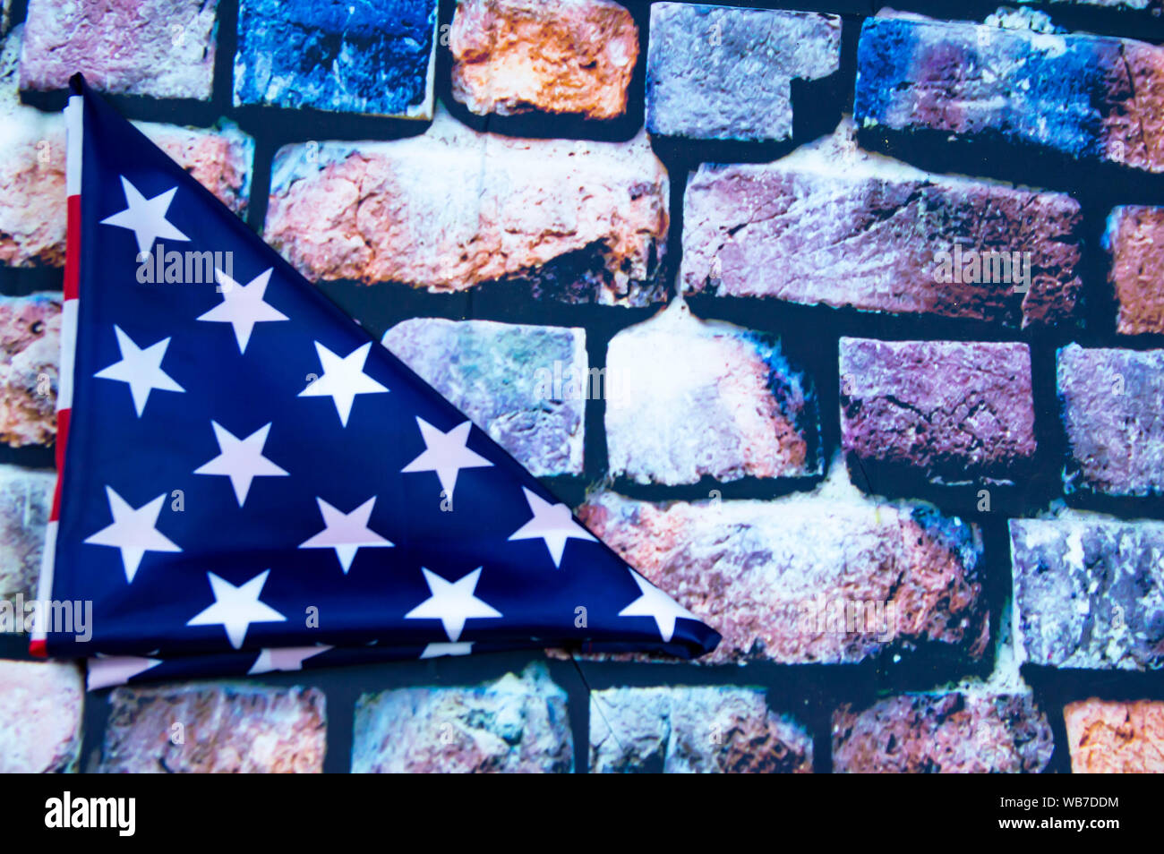 Flag of the United States of America folded in a triangle on a brick ...