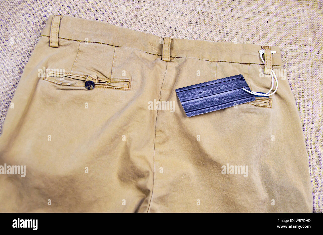 Blank label on gray jeans pants, new clothes. Place for writing text ...