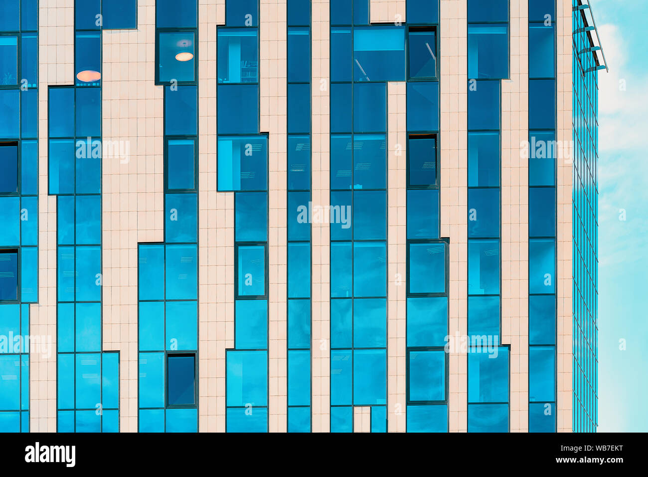 Glass windows reflecting blue sky as details of modern architecture ...