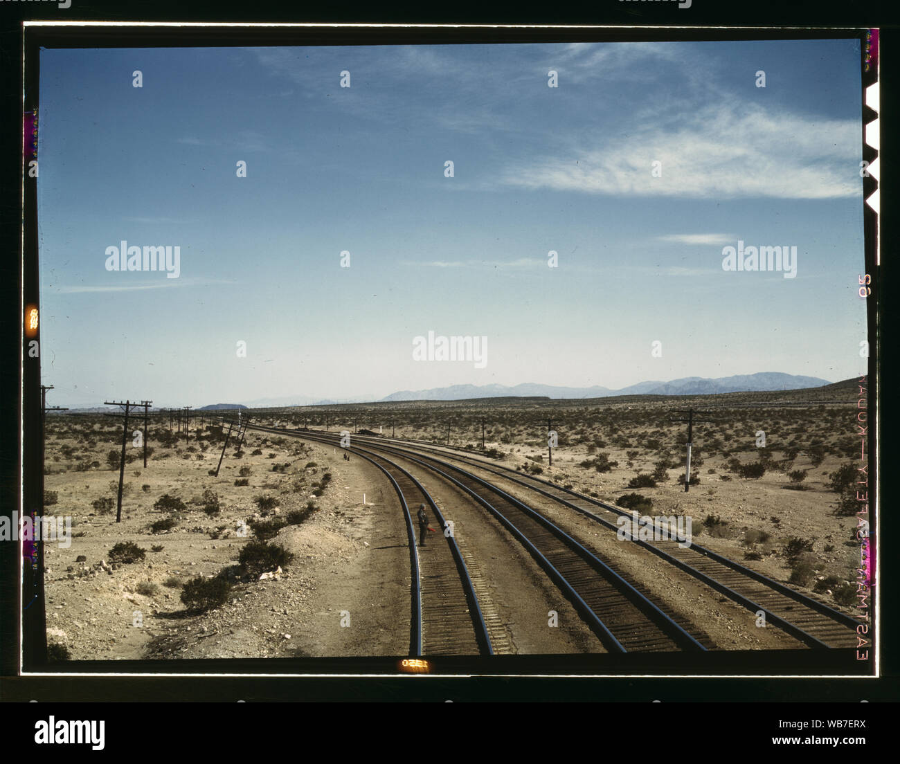 Flagman standing at a distance behind a Santa Fe R.R. west bound ...