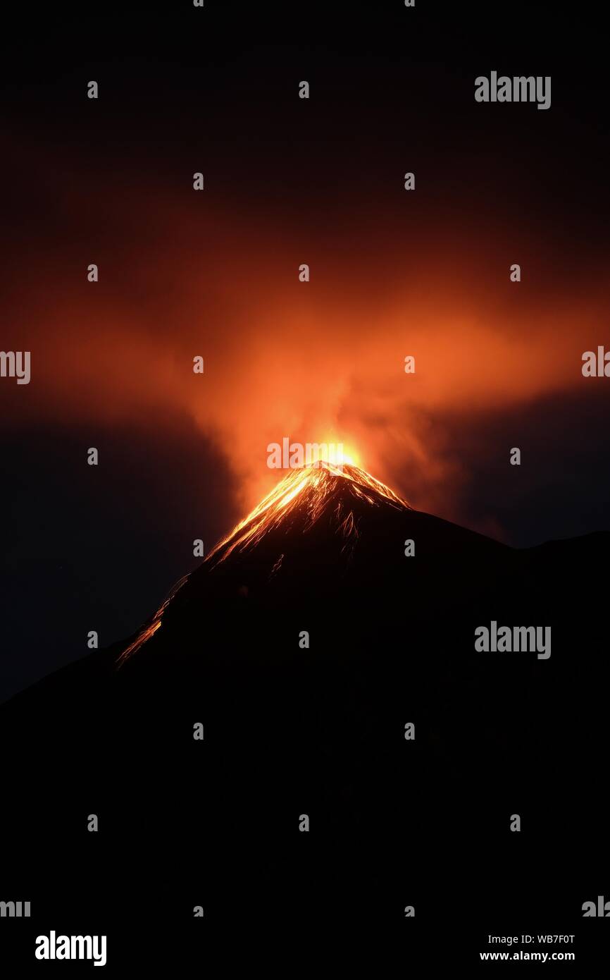 Vertical shot of a beautiful erupting volcano under a dark sky Stock ...