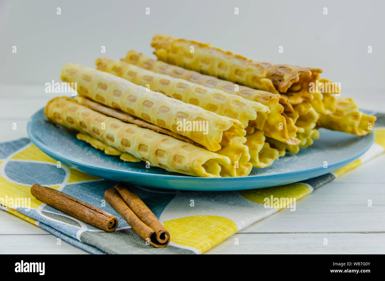 homemade waffle tubes on a blue plate on white background Stock Photo ...
