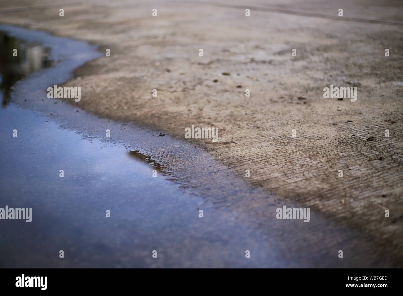 concrete road and flooding water. poor drainage system left puddle of ...