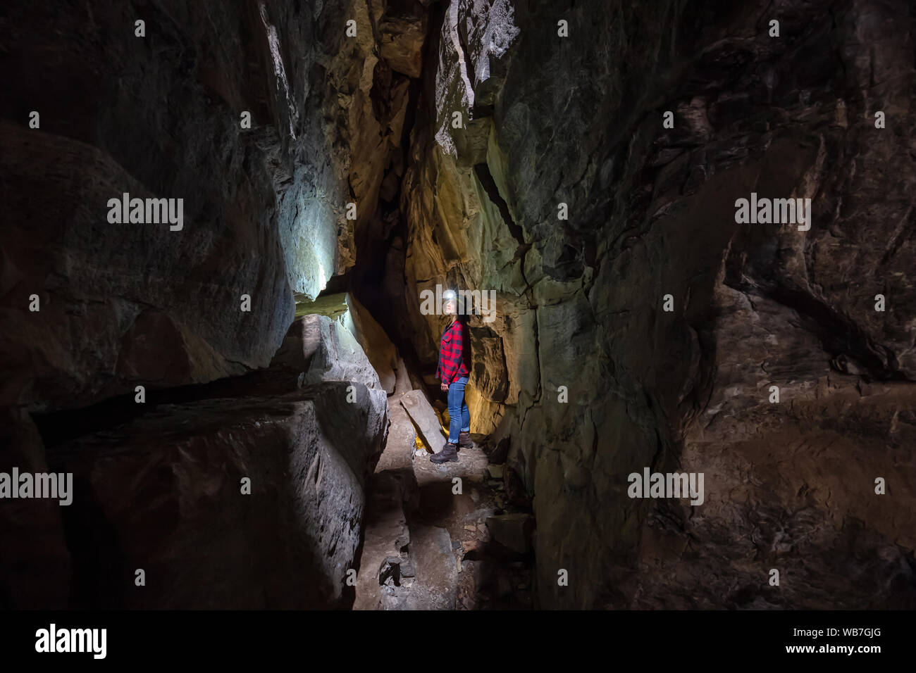 Adventurous girl is exploring the inside of a natural cave in Skaha ...