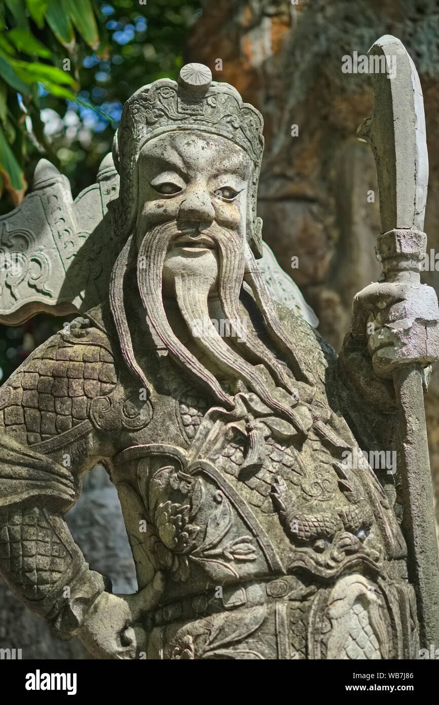 A Chinese guardian figure, with a flowing beard and armed with a lance ...