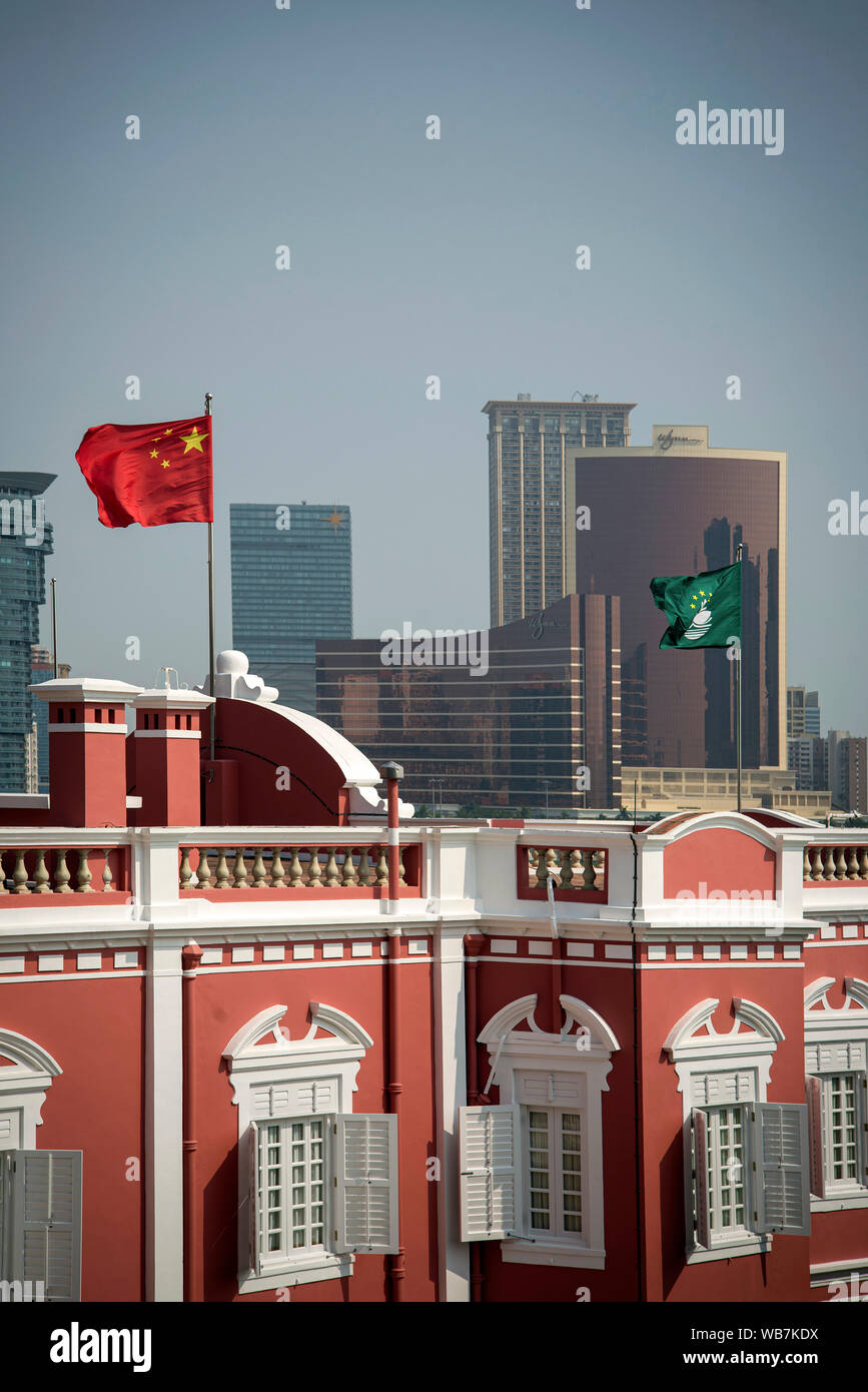 china and macau flags on chinese government headquarters building in ...