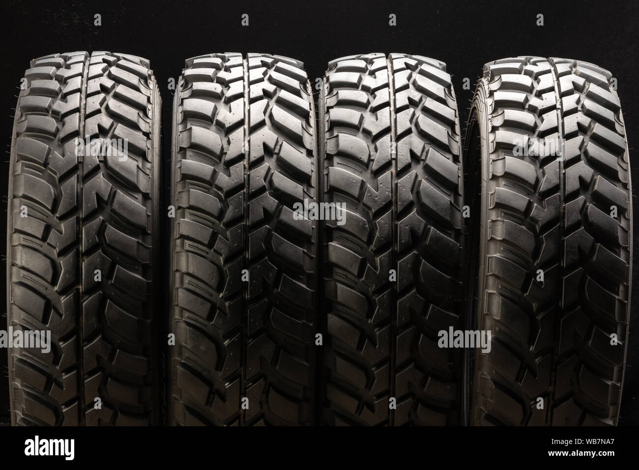 four off-road tires on black background. close up Stock Photo - Alamy