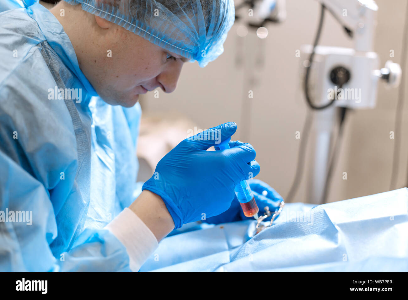 A professional ophthalmologist performs eye surgery with a microscope ...
