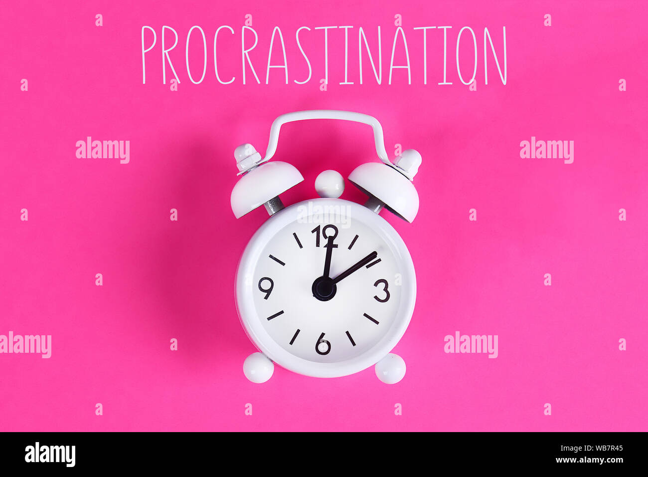 Procrastination, delay and urgency concept. White alarm clock with text ...