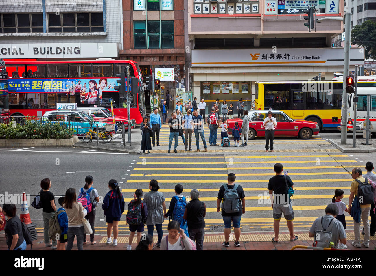 People waiting for green light at pedestrian crossing on Hennessy Road ...