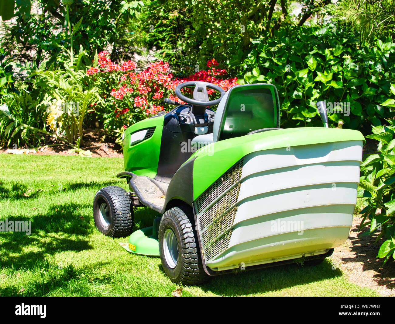 Senior man 75 old years driving a tractor lawn mower in garden with ...