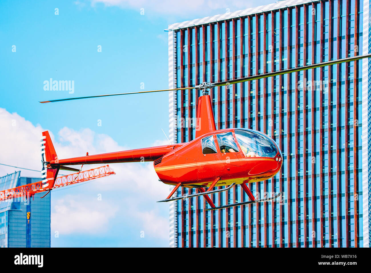 Red helicopter flying above modern skyscraper at the city downtown Stock Photo - Alamy
