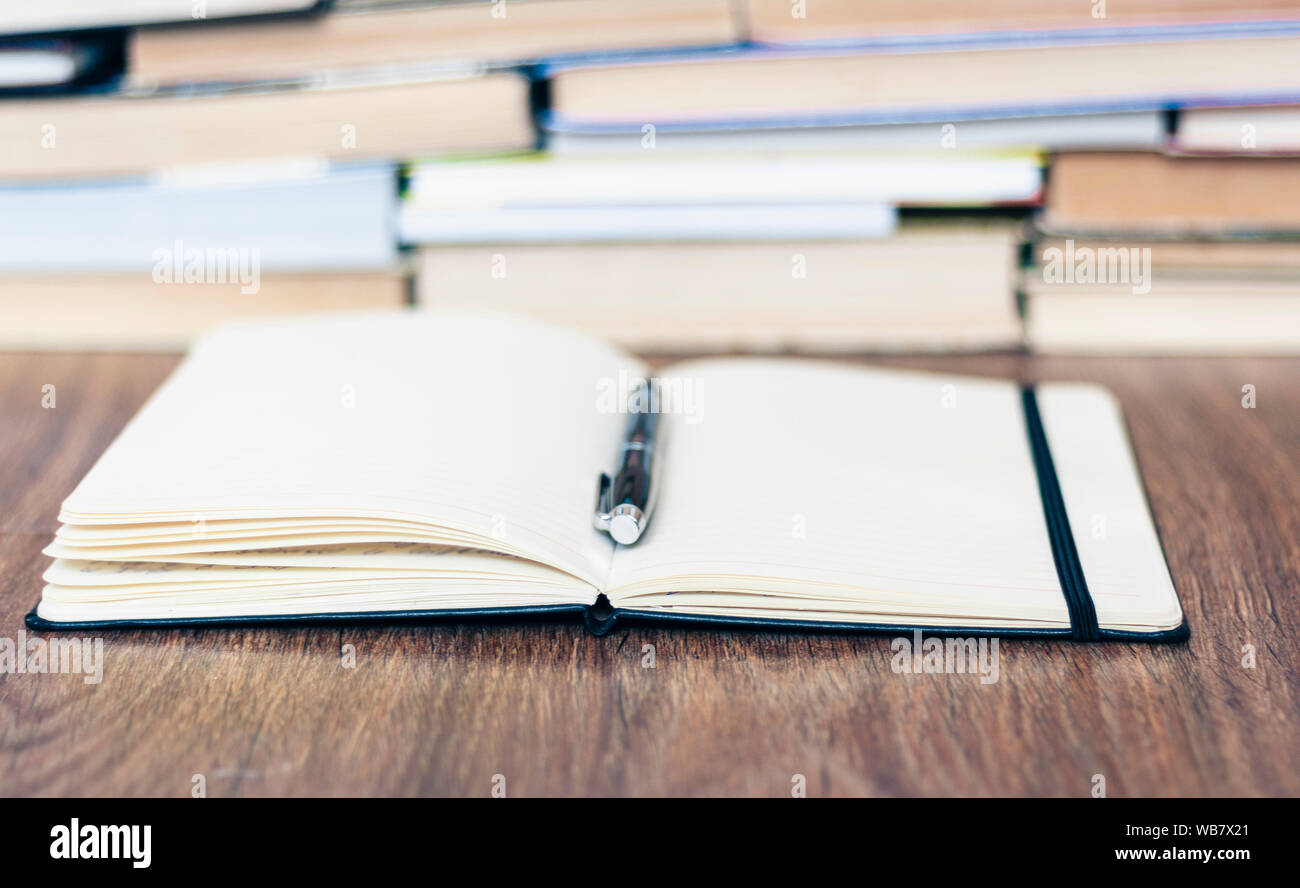 Stack of old book, open notebook and pen. Education concept background ...
