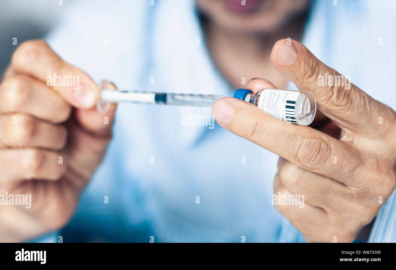 Pile of medical syringes and bottle of insulin for diabetes in woman ...