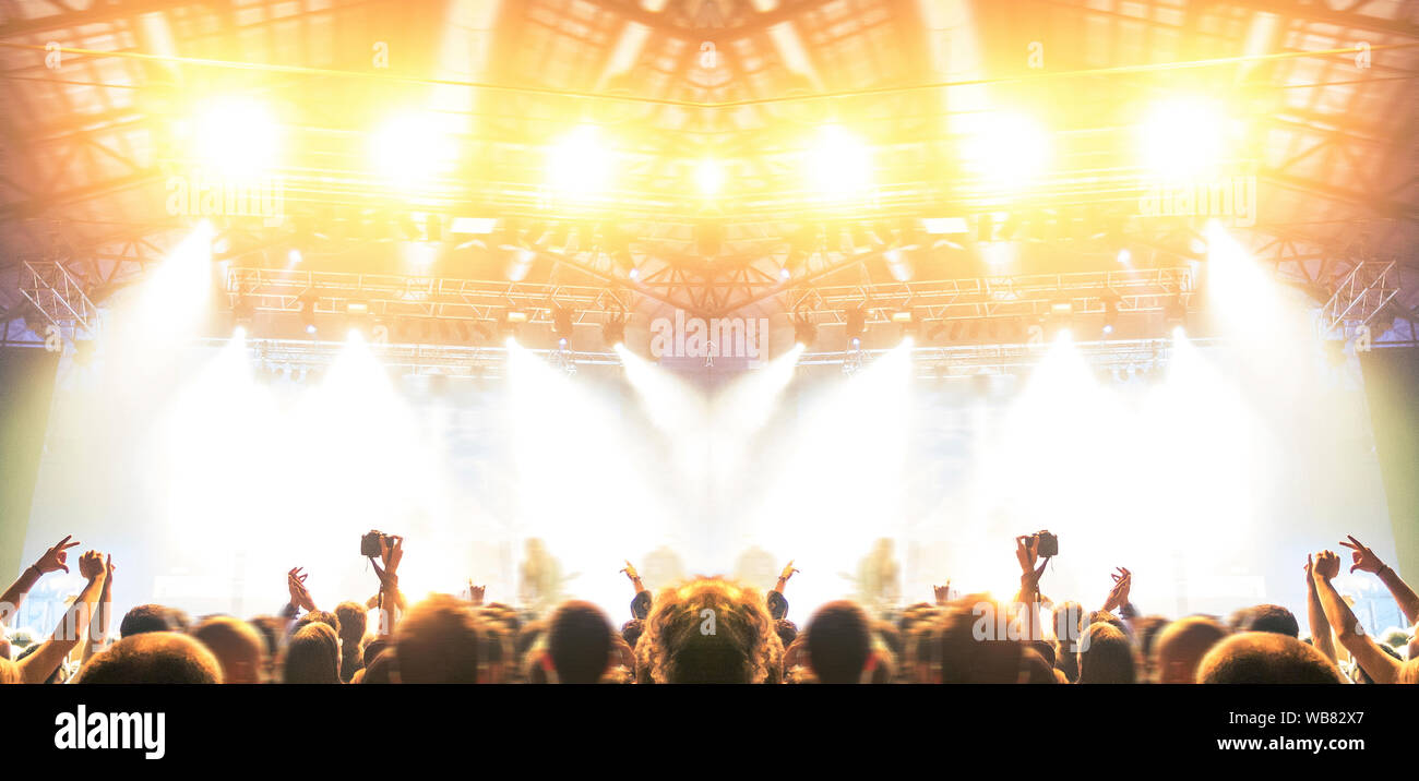 Colourful shot taken inside a concert venue, people silhouettes are ...