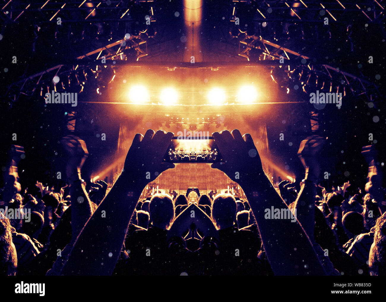 Colourful shot taken inside a concert venue, people silhouettes are ...