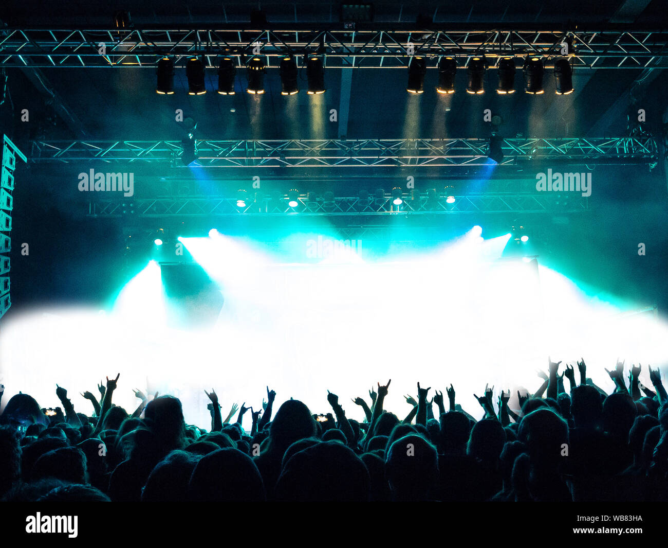 Colourful shot taken inside a concert venue, people silhouettes are ...