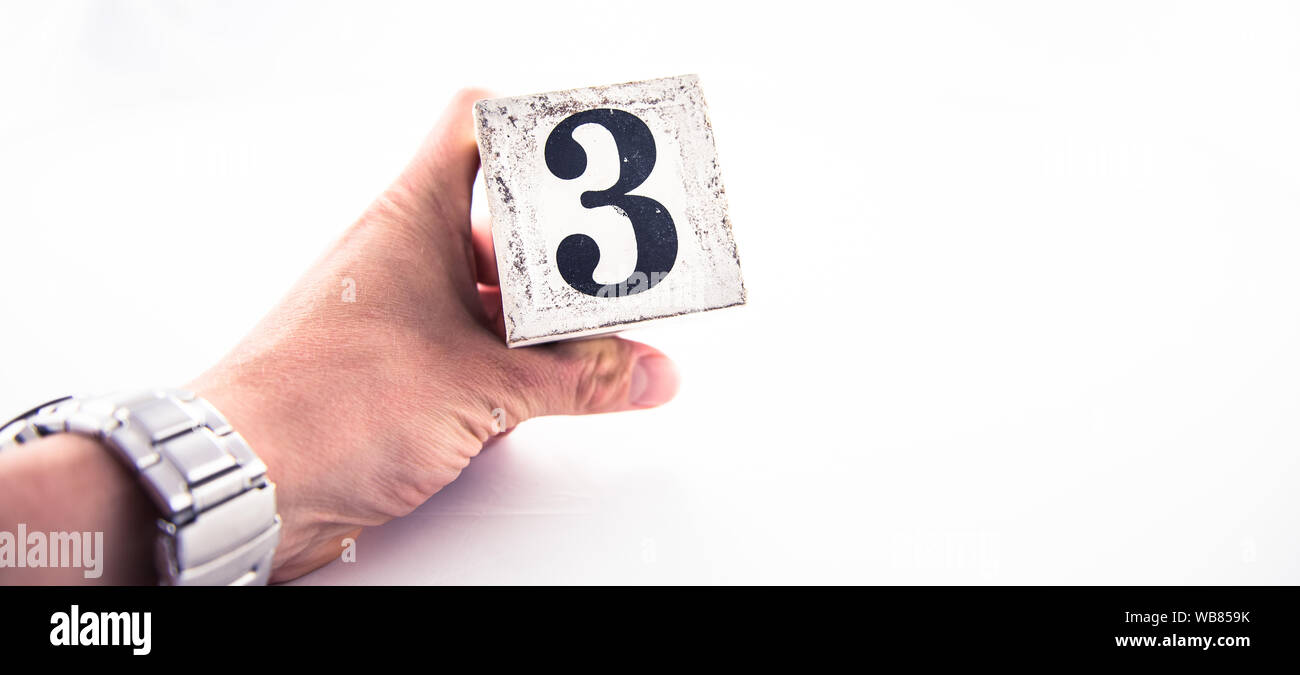 A hand holding digit number 3 (three) on white background Stock Photo ...