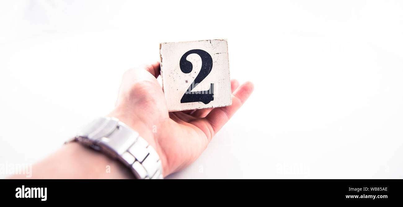A hand holding digit number 2 (two) on white background Stock Photo - Alamy