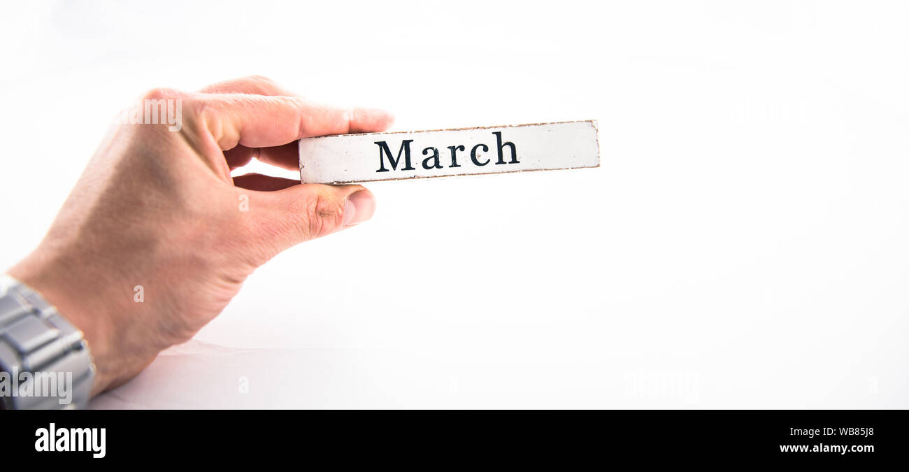 March - A hand holding calendar month block on white background Stock ...