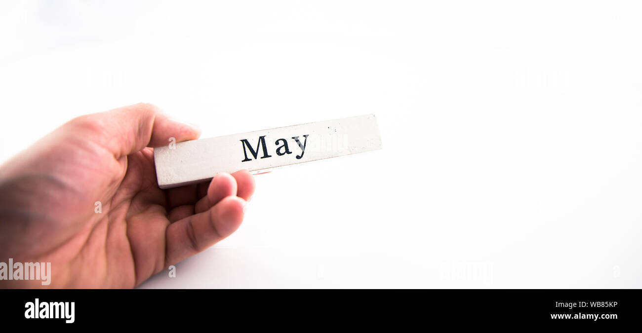 May - A hand holding calendar month block on white background Stock ...