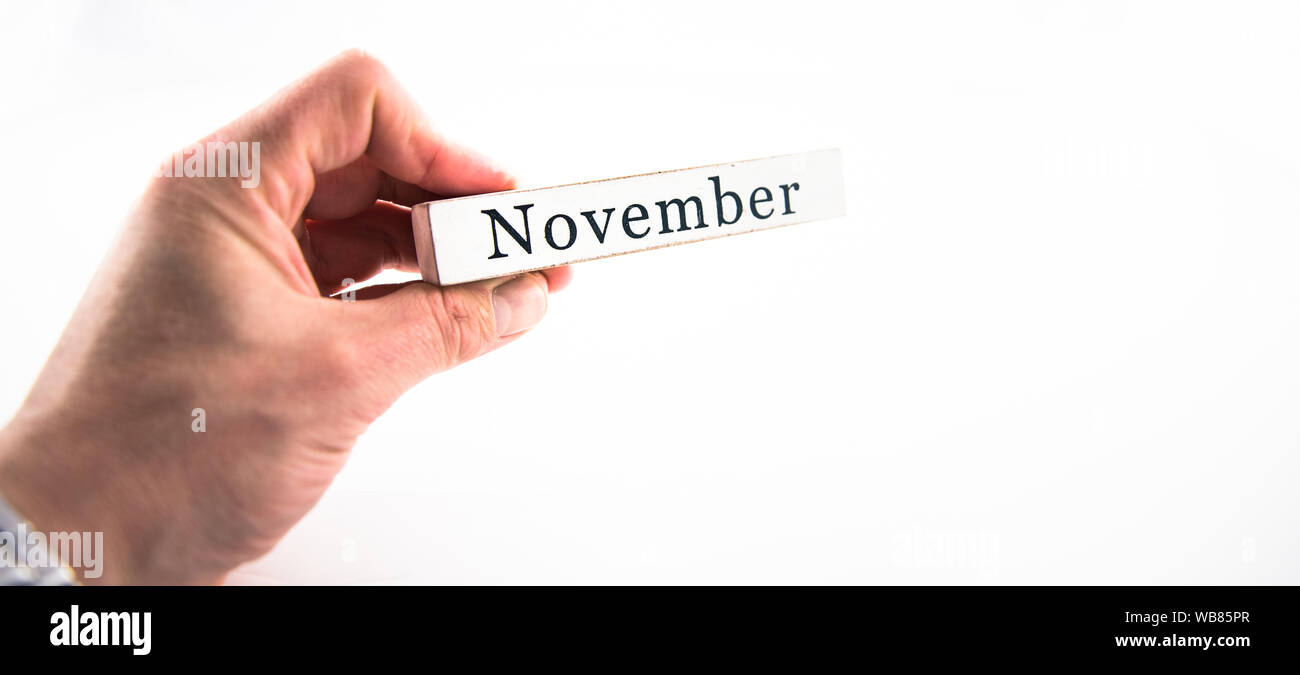November - A hand holding calendar month block on white background ...