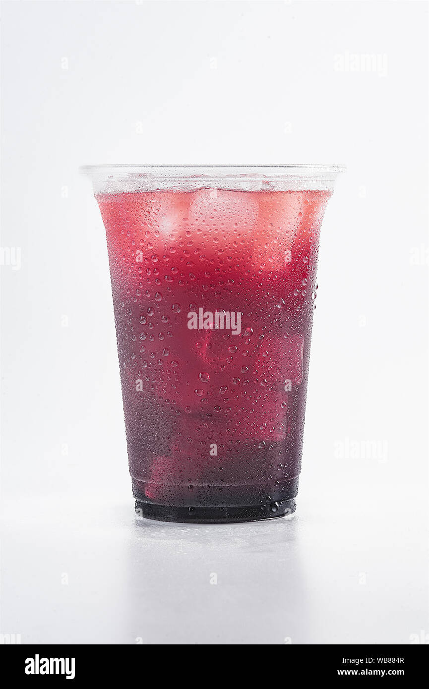 Cold drink with syrup and ice cubes on a white background. Drink in a ...