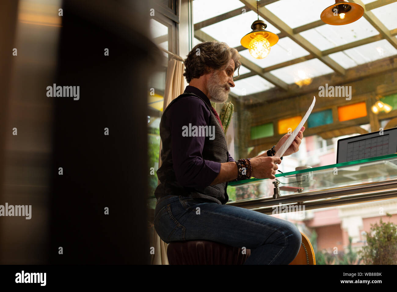 Thoughtful man studying a coffee shop menu Stock Photo - Alamy