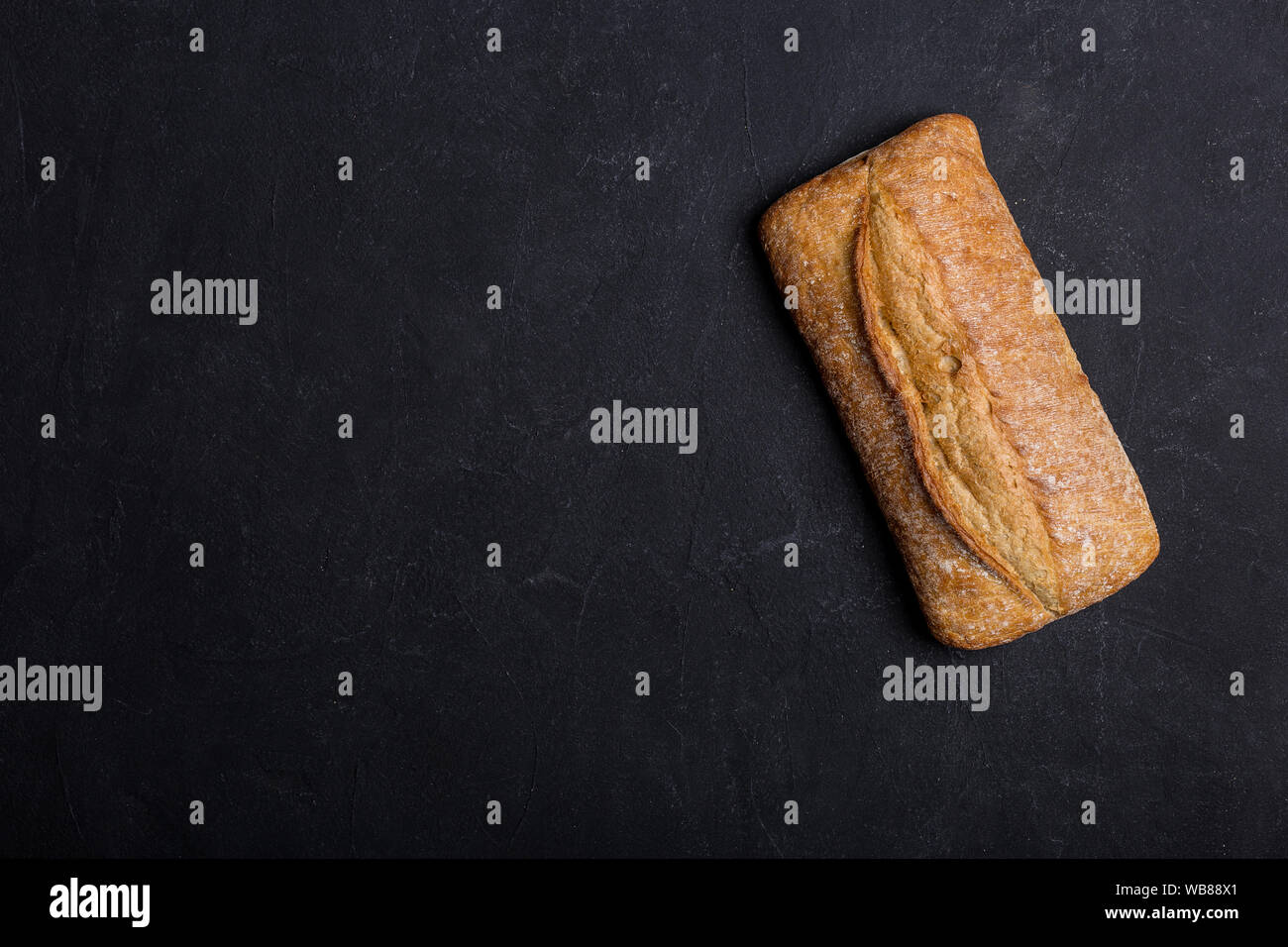 Beautiful tasty loaf of grain bread on black background. Concept of ...