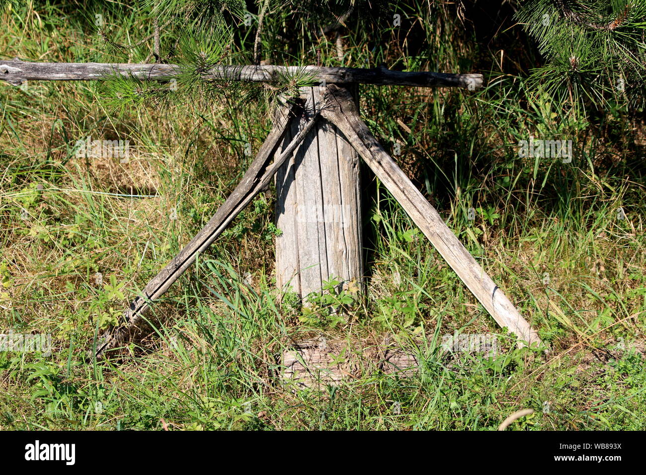 Part of small wooden fence made of dried cracked dilapidated tree logs ...