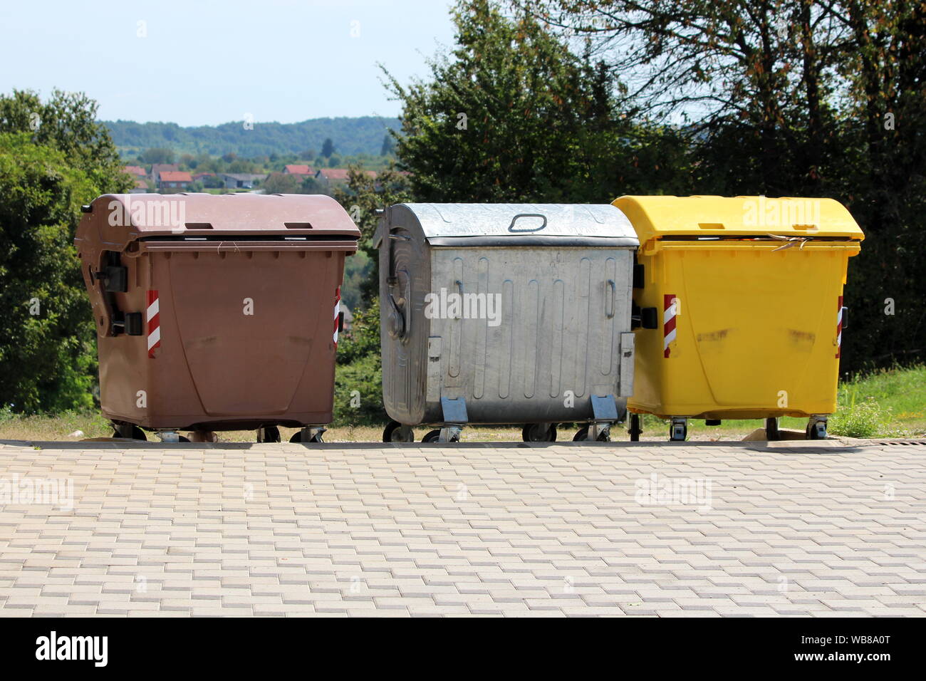 Three various large metal and plastic trash containers for ecologically ...