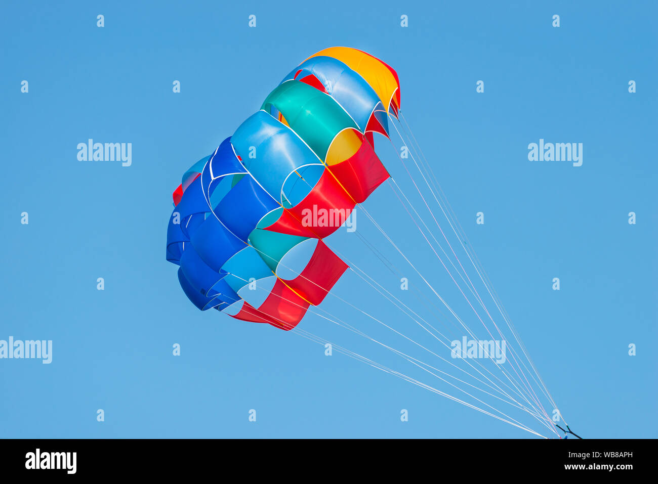 Close up shot of a colorful parachute used for parasailing pulled by a ...