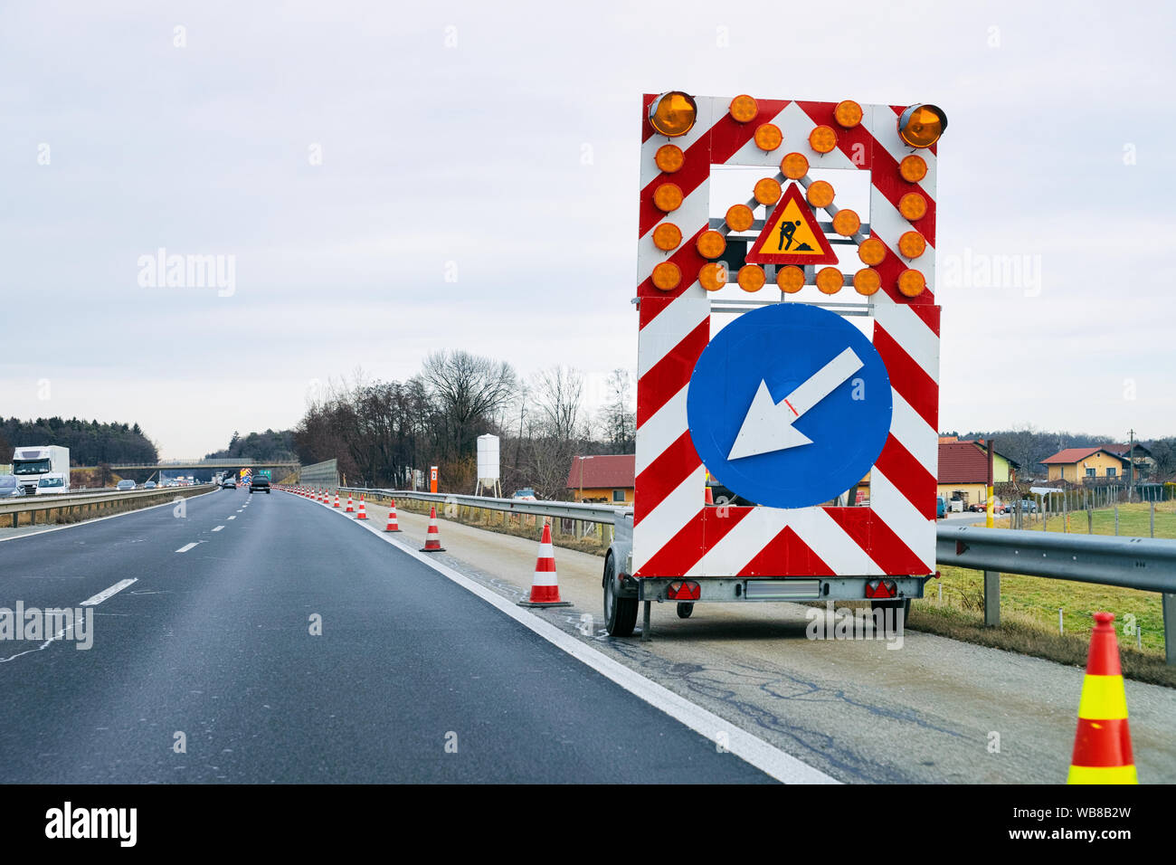 Arrow down left reflective direction road sign in highway. Roadwork ...