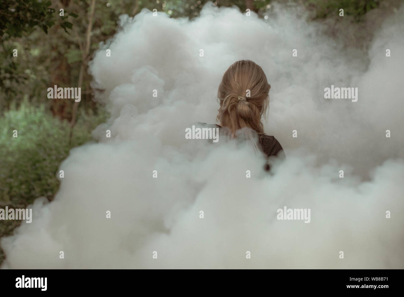Girl around white smoke in the forest Stock Photo - Alamy