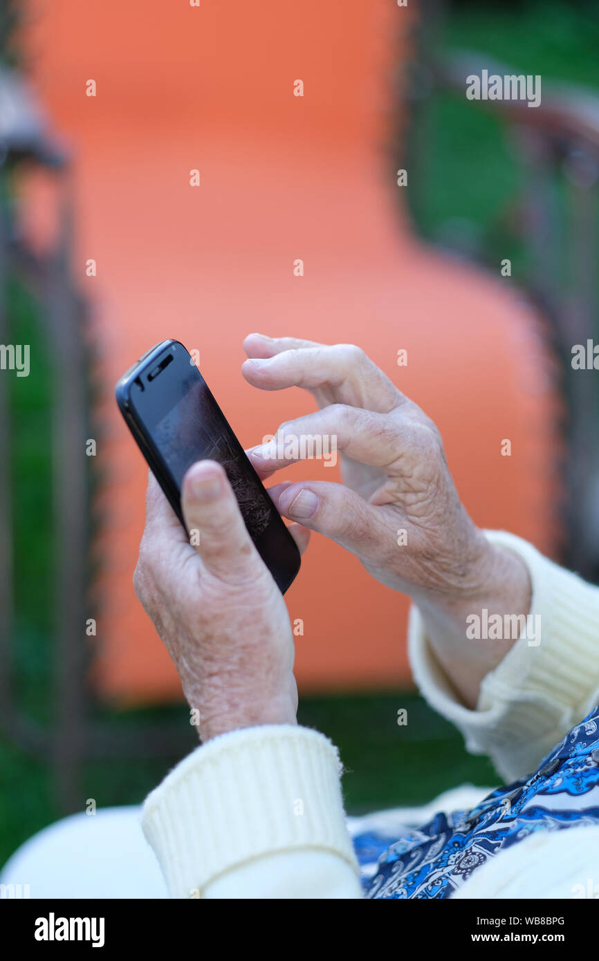 Wrinkled hands of an elderly woman with a mobile phone Stock Photo - Alamy