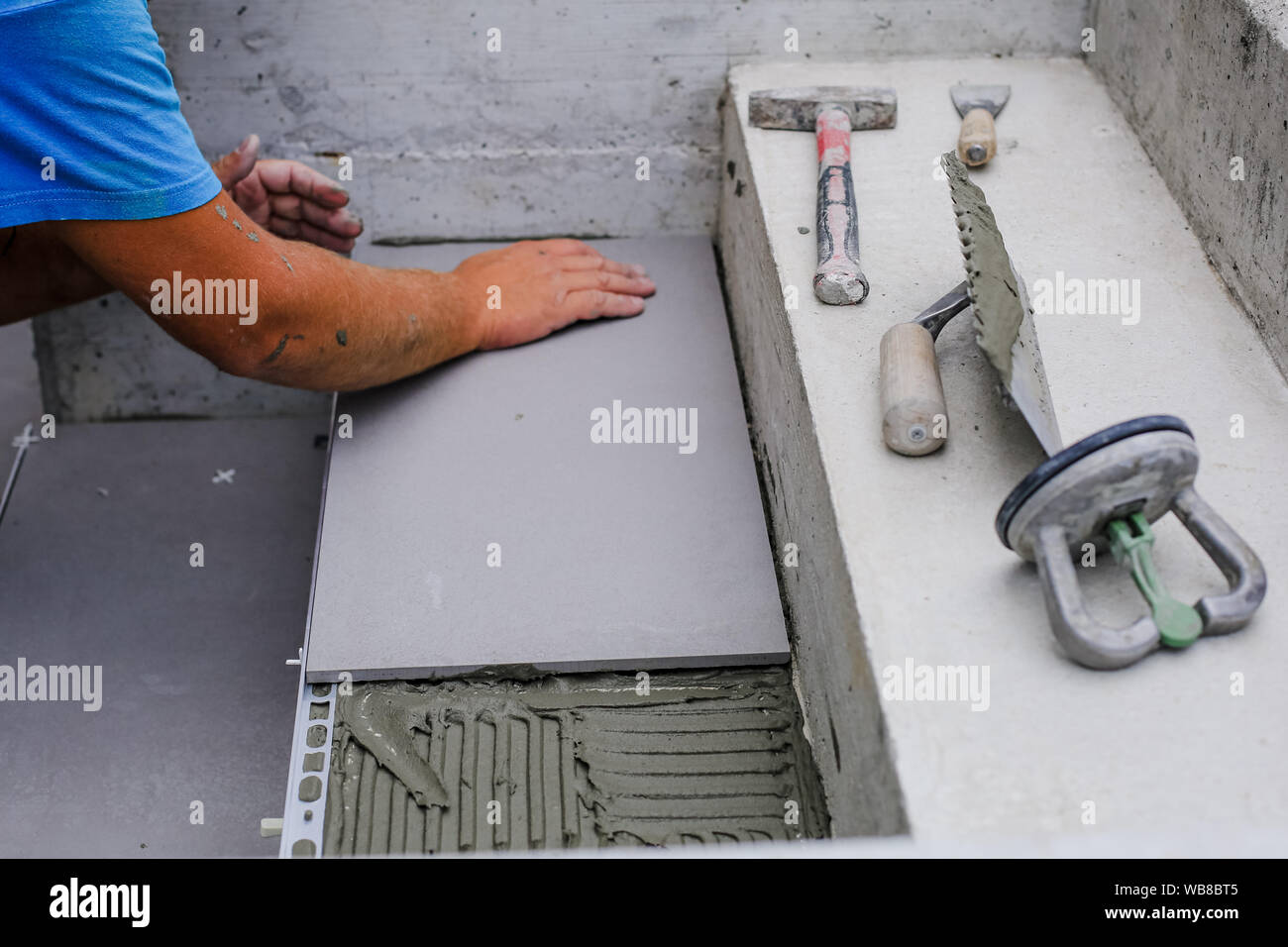 Tiler hands working on a new house entrance, local and professional ...