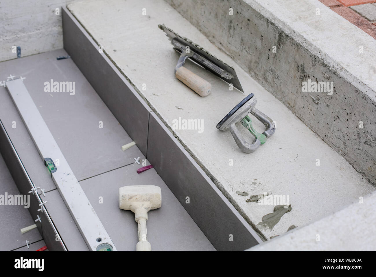 Laying new tiles on a concrete steps outside of a building Stock Photo ...